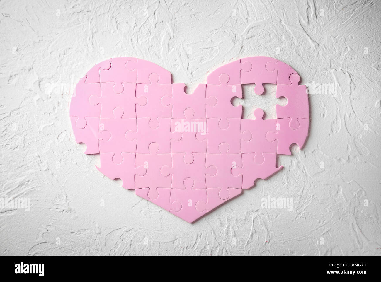 Heart made of pink puzzles on light background Stock Photo - Alamy