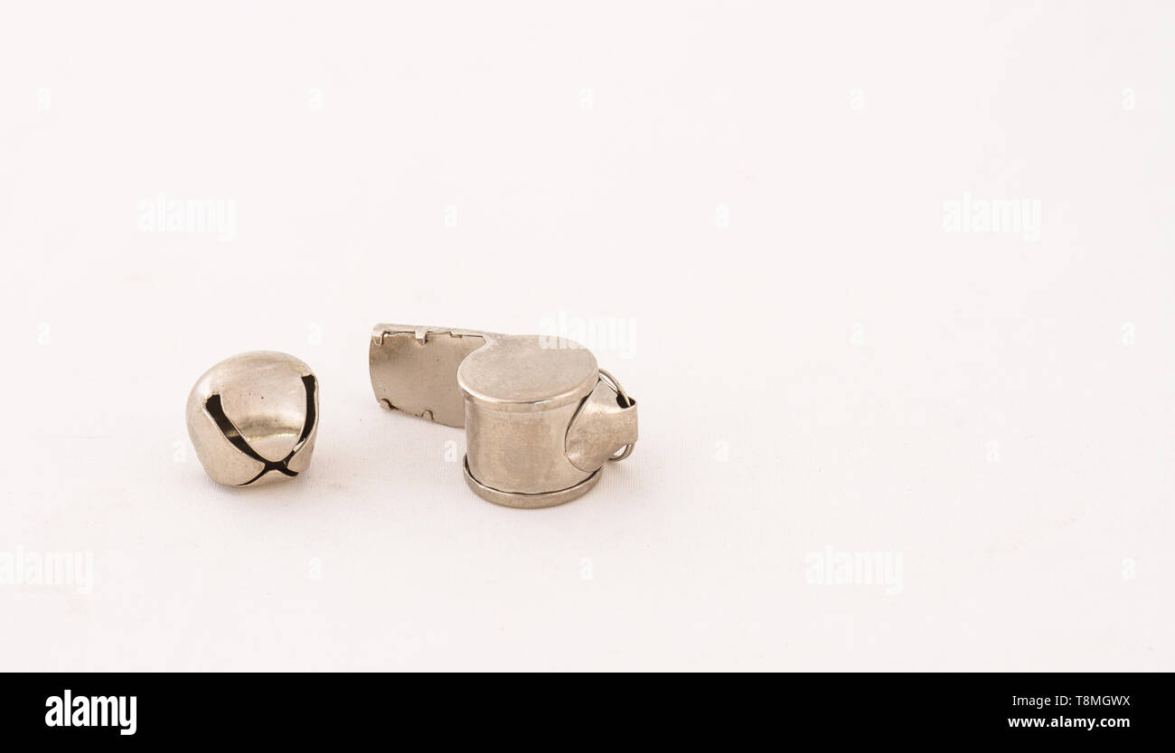 Two whistles and a silver bell isolated on a white background image ...