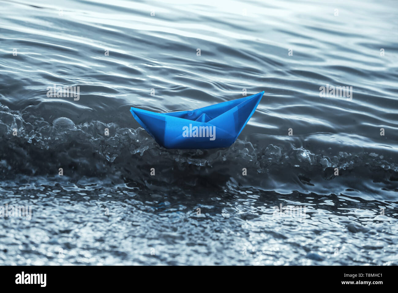 Origami boat on water surface near bank Stock Photo - Alamy