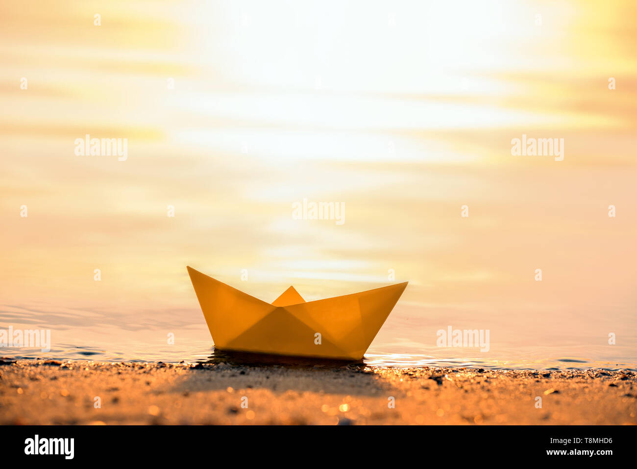 Origami boat on water surface near bank Stock Photo - Alamy