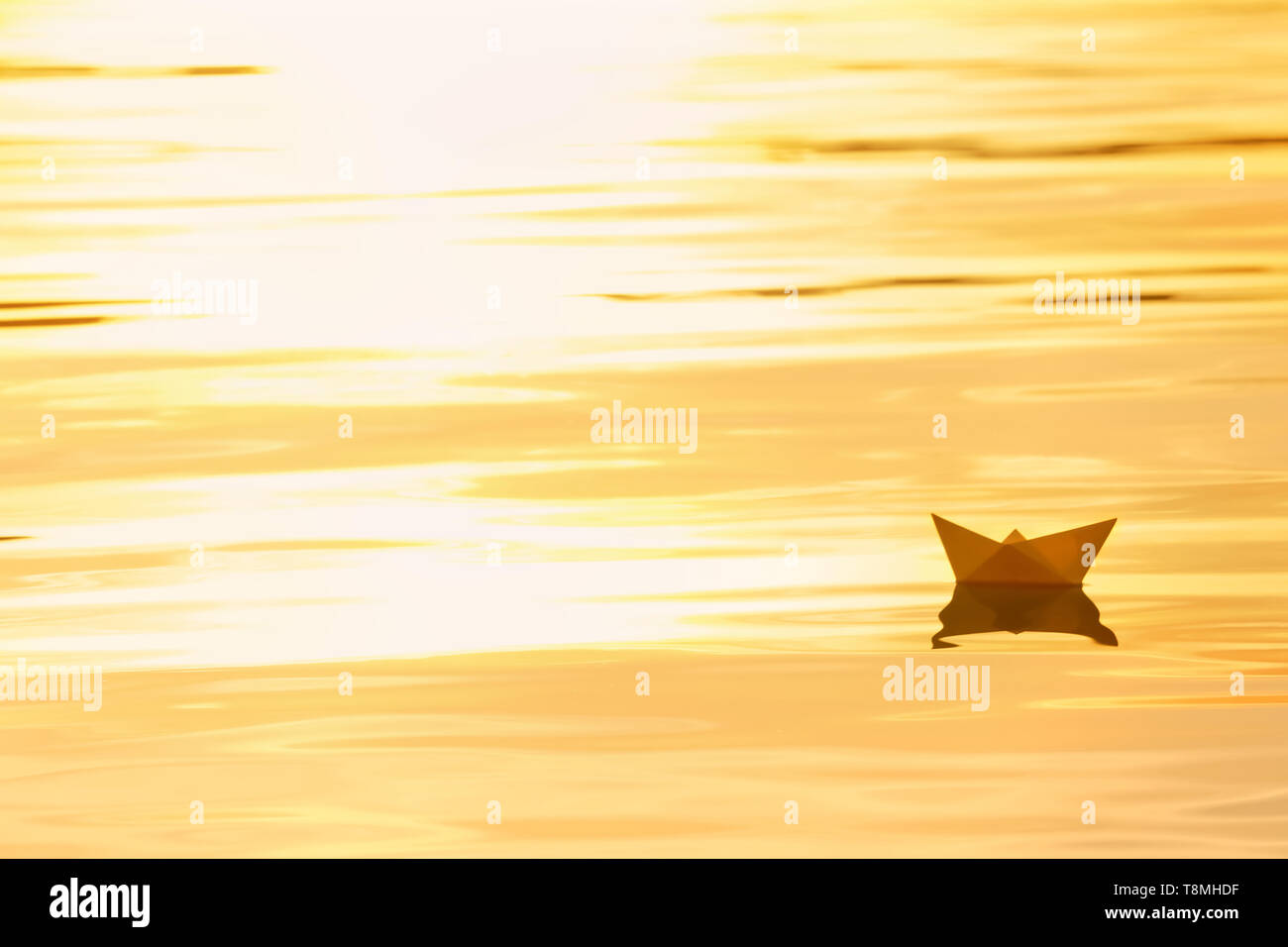 Origami boat on water surface at sunset Stock Photo - Alamy
