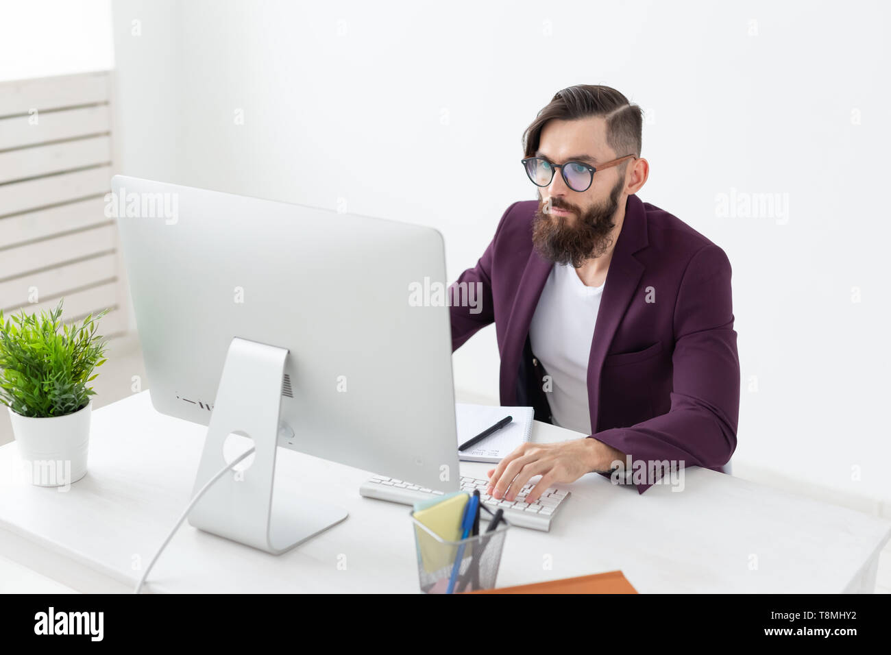 People and technology concept - Handsome man with beard working on at ...
