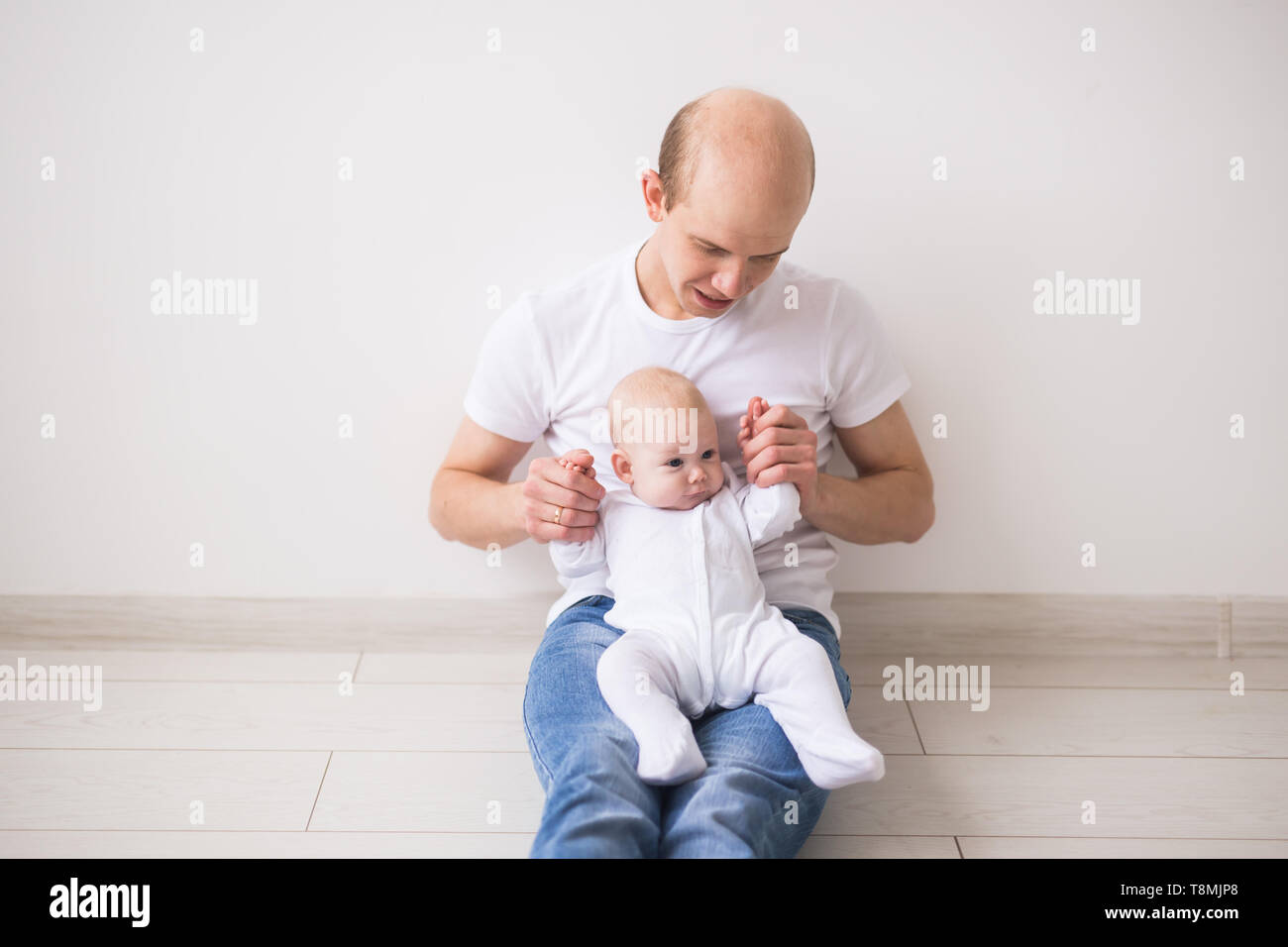Infant, family and fatherhood concept - Bald father sitting on the ...