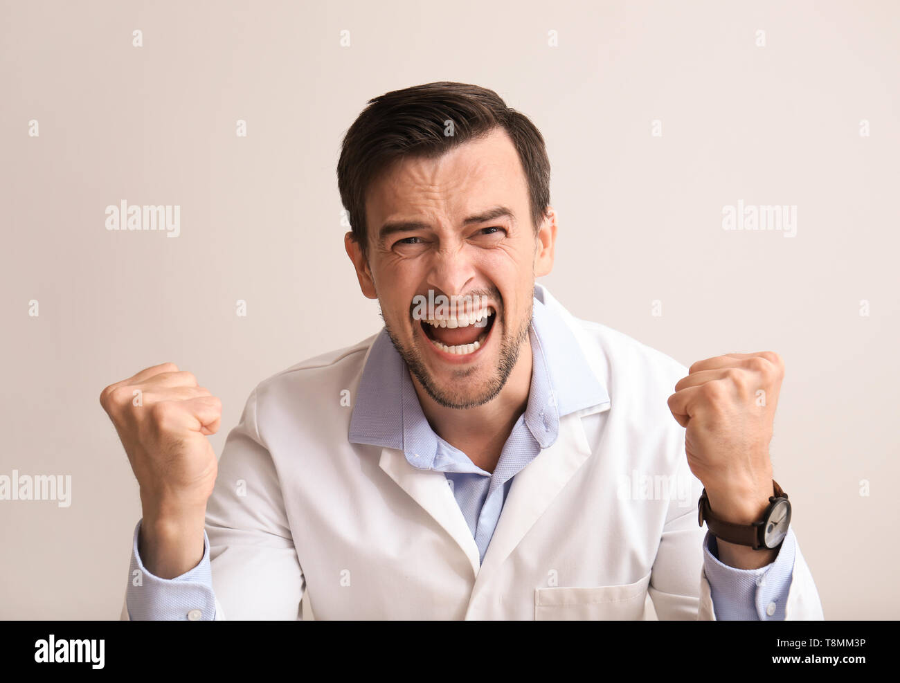 Handsome stressed doctor on white background Stock Photo - Alamy