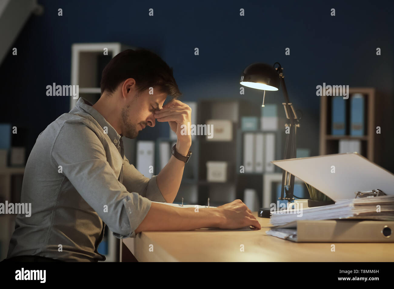Tired man working late in evening Stock Photo - Alamy