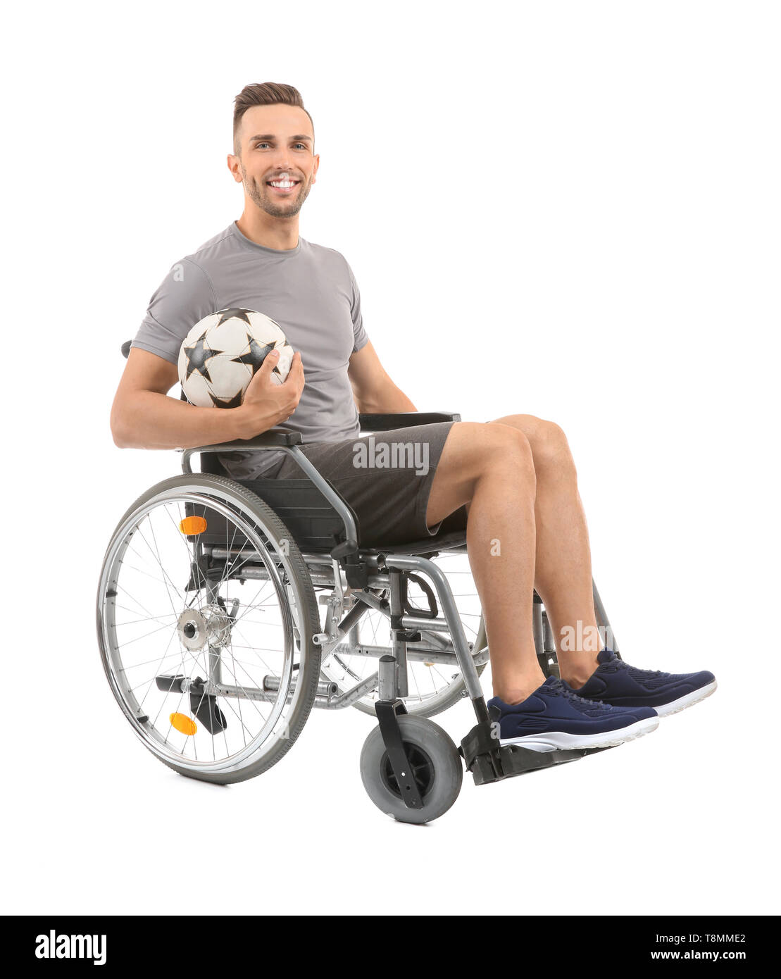 Young man with ball sitting in wheelchair on white background Stock ...