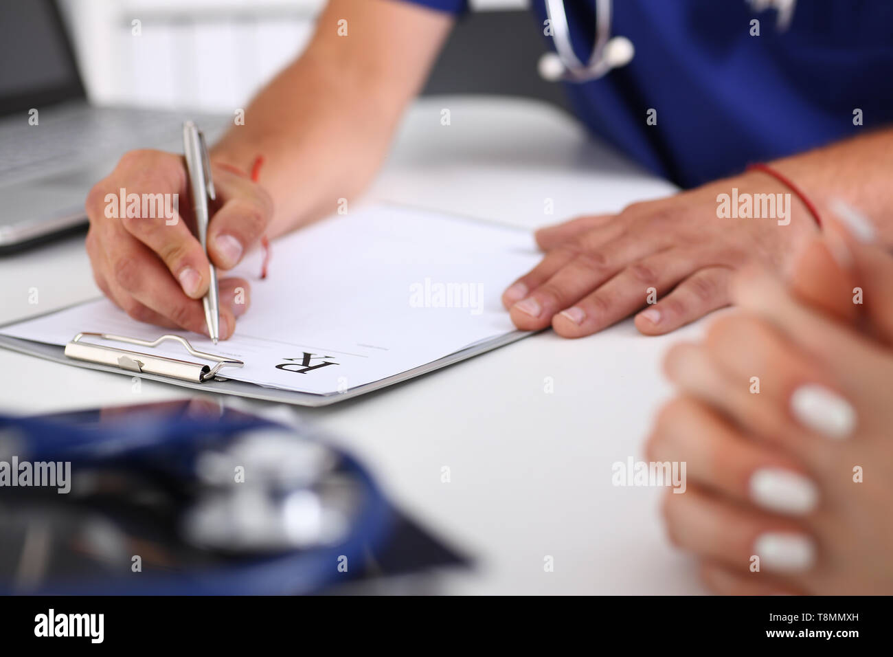Male doctor hand write prescription at office worktable Stock Photo - Alamy