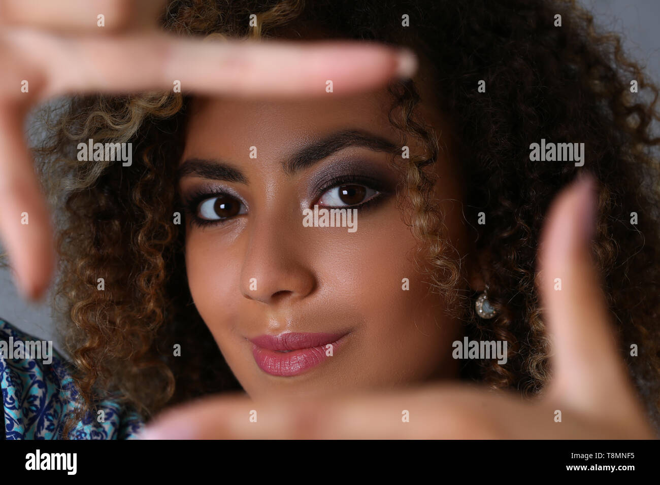Playful female showing frame gesture Stock Photo - Alamy