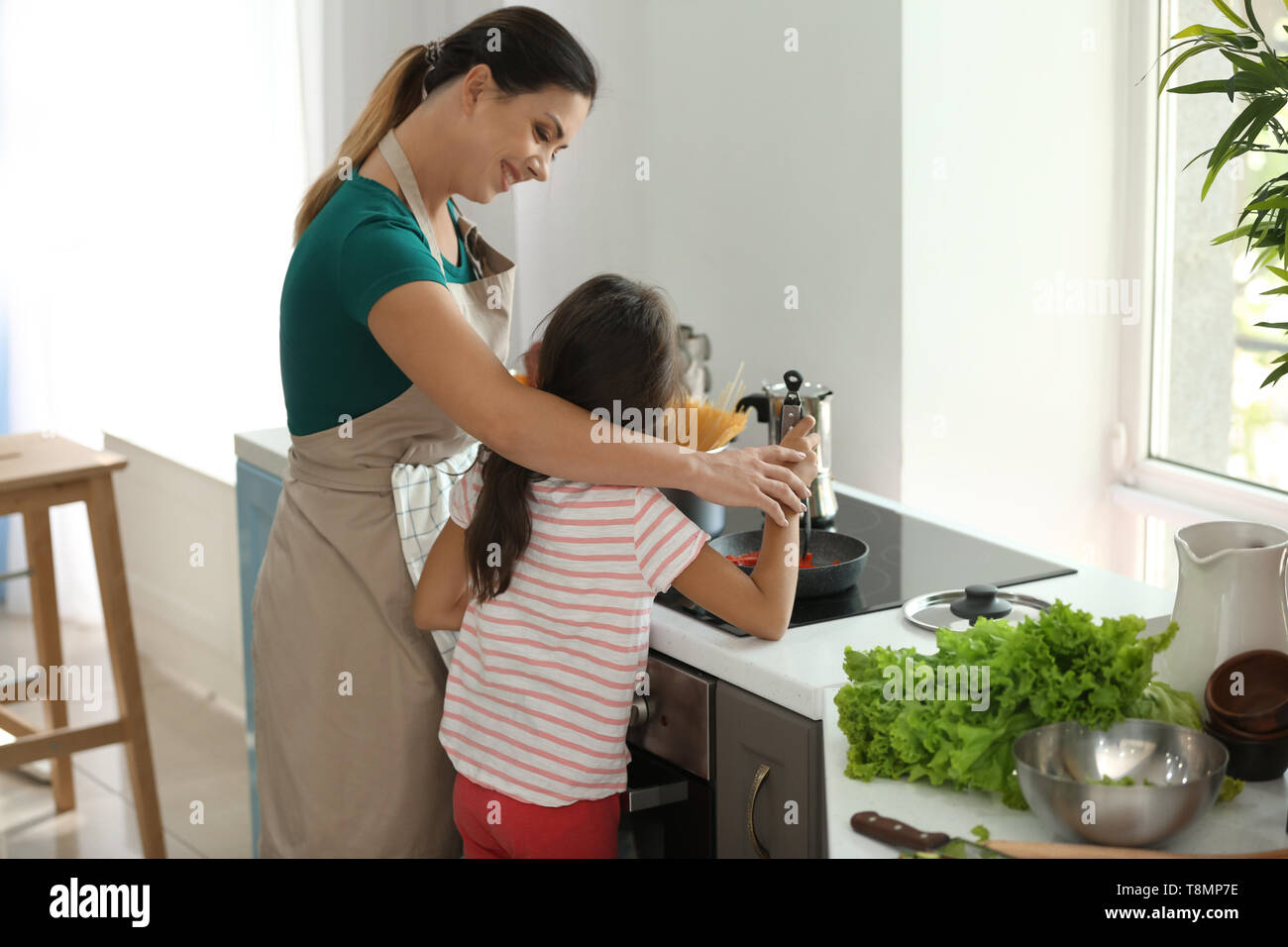 Mother and daughter cooking together in kitchen Stock Photo - Alamy