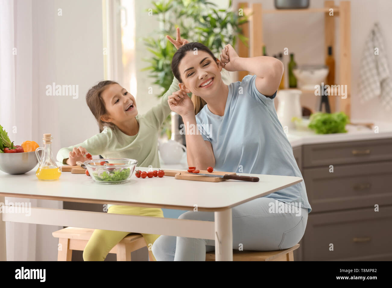 Mother and daughter having fun while cooking in kitchen Stock Photo - Alamy