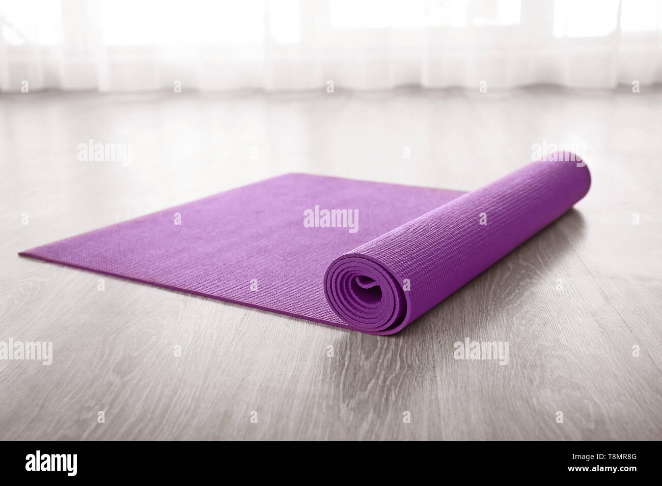 Purple yoga mat on floor indoors Stock Photo - Alamy