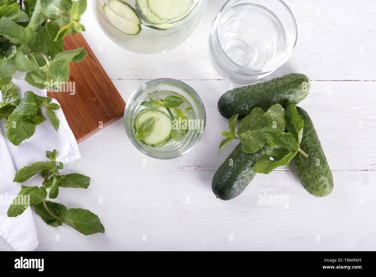Glass of tasty fresh cucumber water with ingredients on white wooden table Stock Photo - Alamy