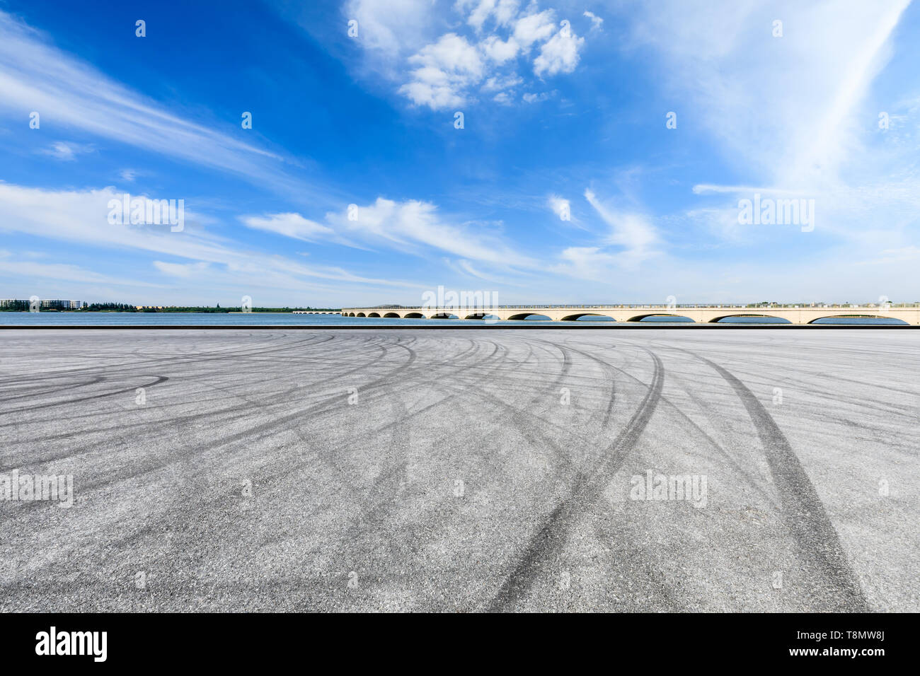 Asphalt race track ground and lake with bridge under blue sky Stock ...