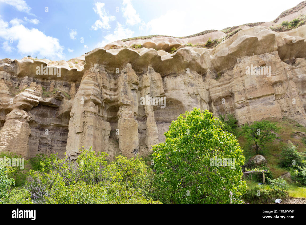 Red and white sandstone cliffs, ancient caves in a mountain landscape ...