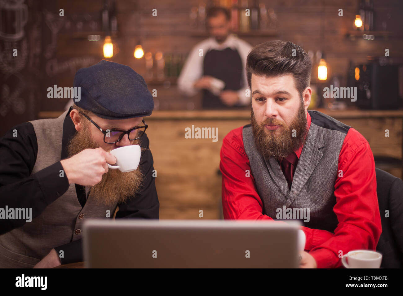 Two succesful bearded men enjoying their coffee in a vintage pub ...