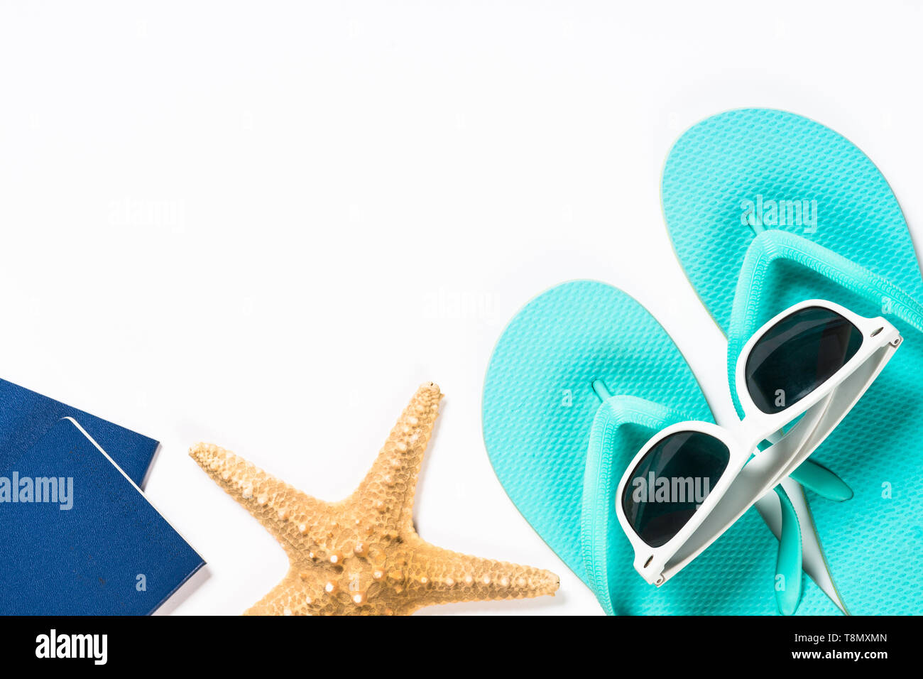 Blue flip flops, sunglasses, passport and starfish on white background ...