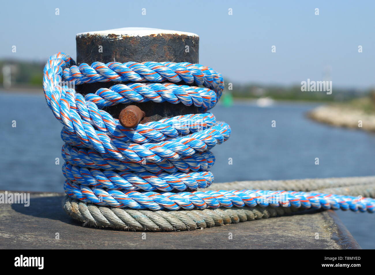 Blue rope around a bollard at a quay Stock Photo - Alamy