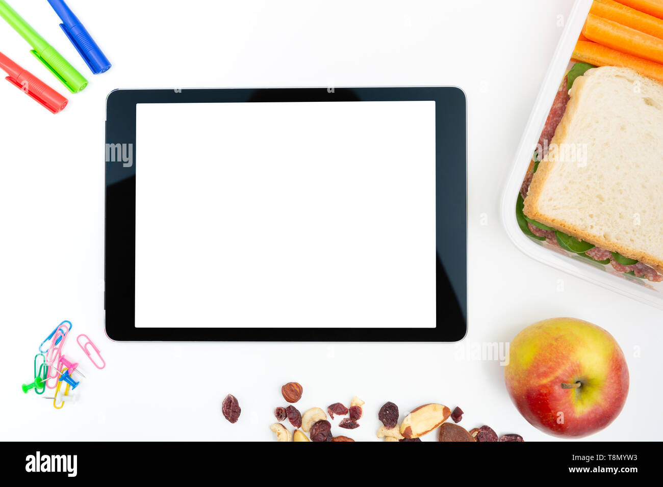 Healthy eating a sandwich in lunch box at work with tablet on white ...