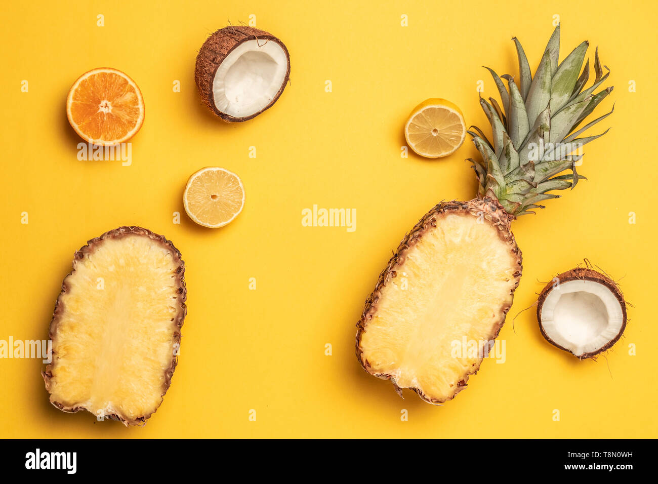 Tropical fruit flat lay with pineapple, oranges, lemon and coconut on a ...