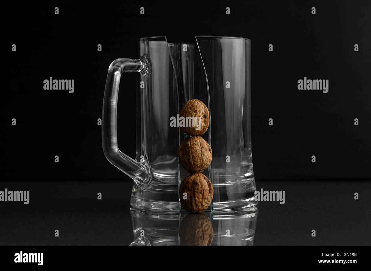 cracked beer mug with three walnuts on a dark background Stock Photo ...