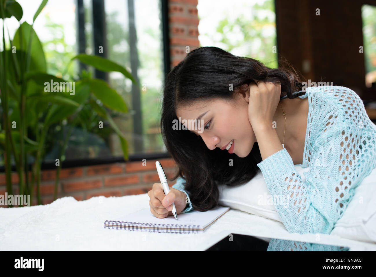 Beautiful young asian woman laying on bed and writing a diary Stock ...