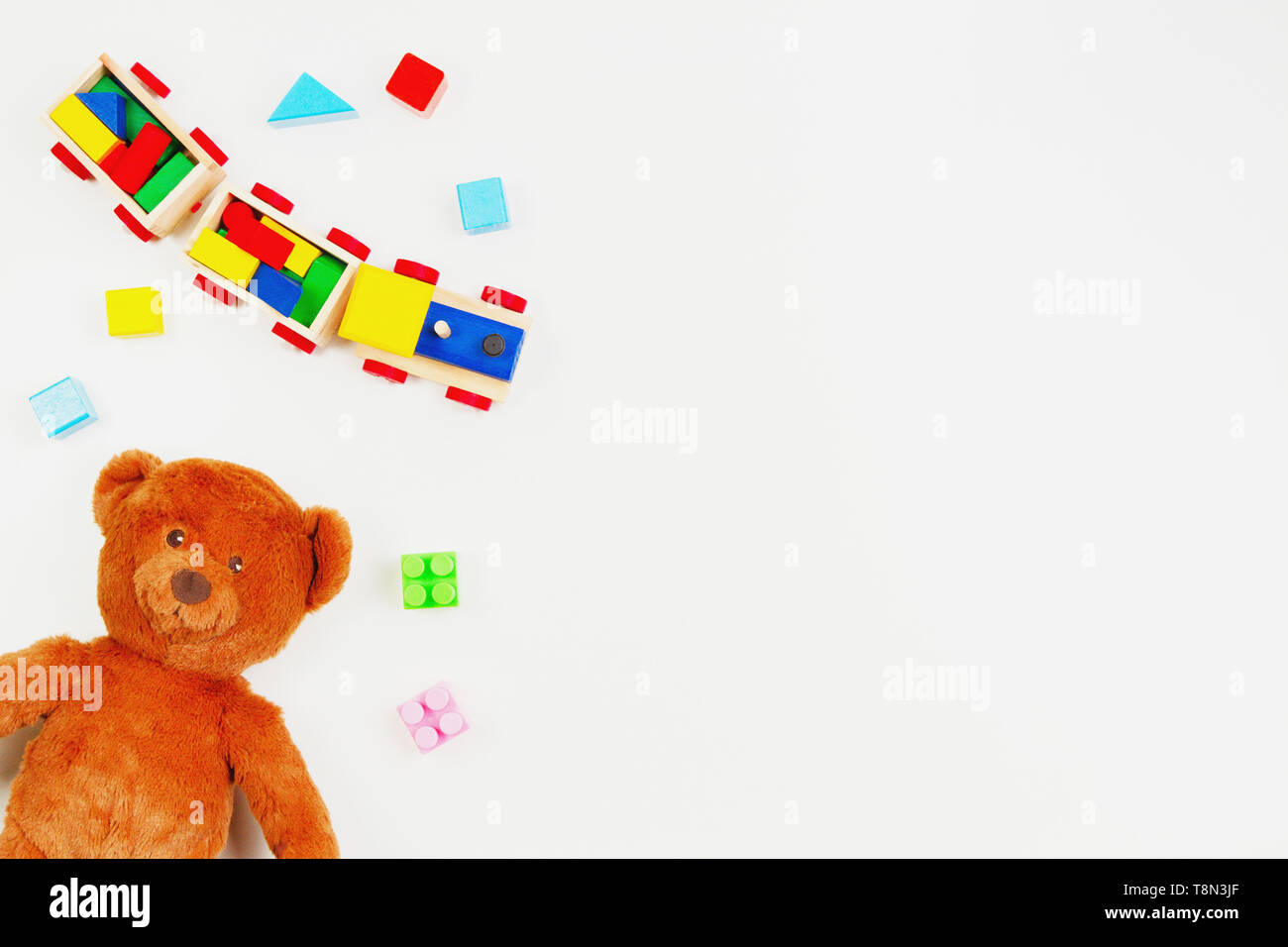 Baby kids toys background. Teddy bear, wooden train, colorful bricks on ...