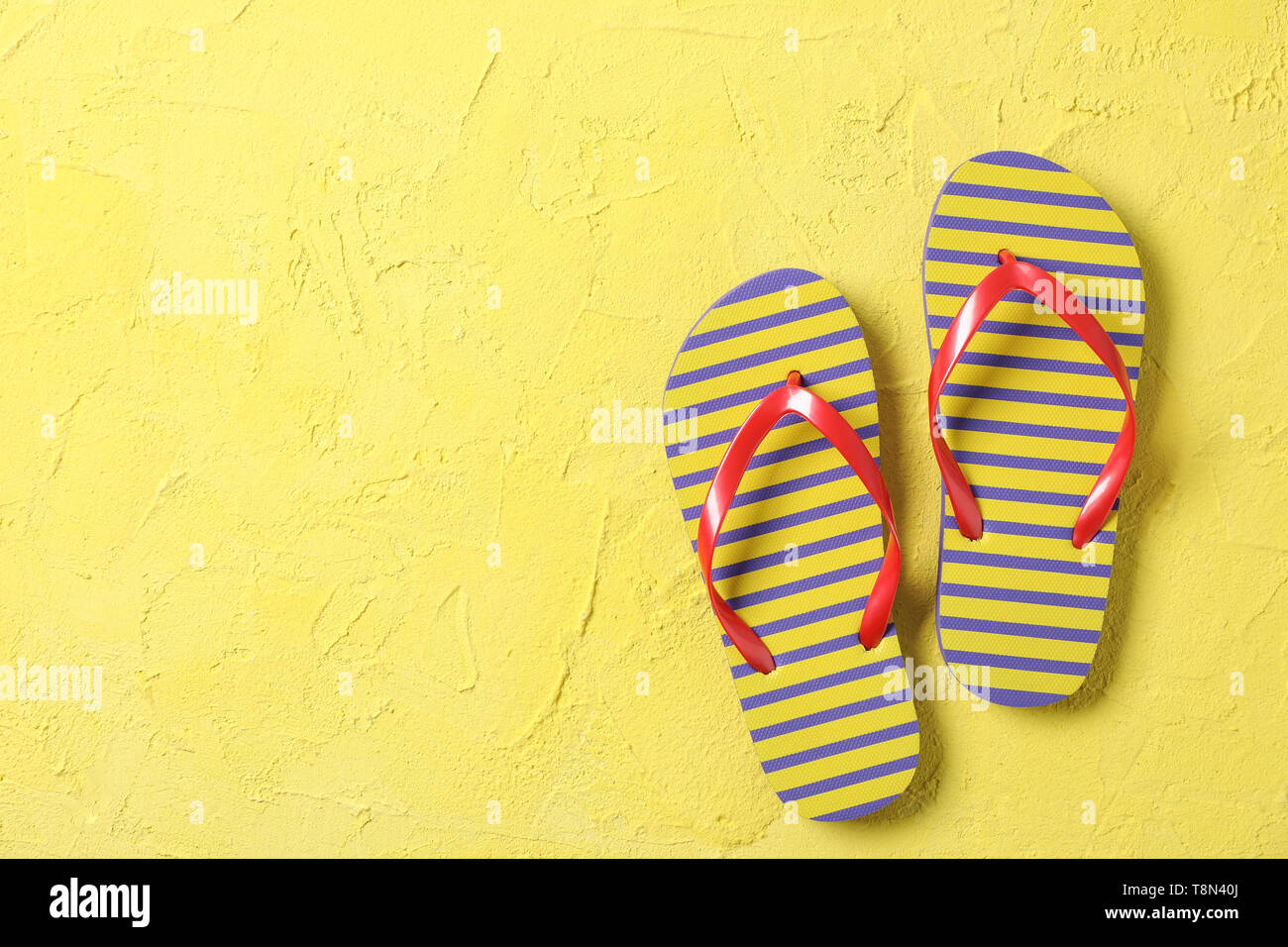 Flip flops on color background, space for text and top view. Summer ...