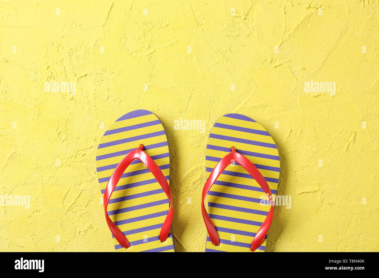 Flip flops on color background, space for text and top view. Summer ...