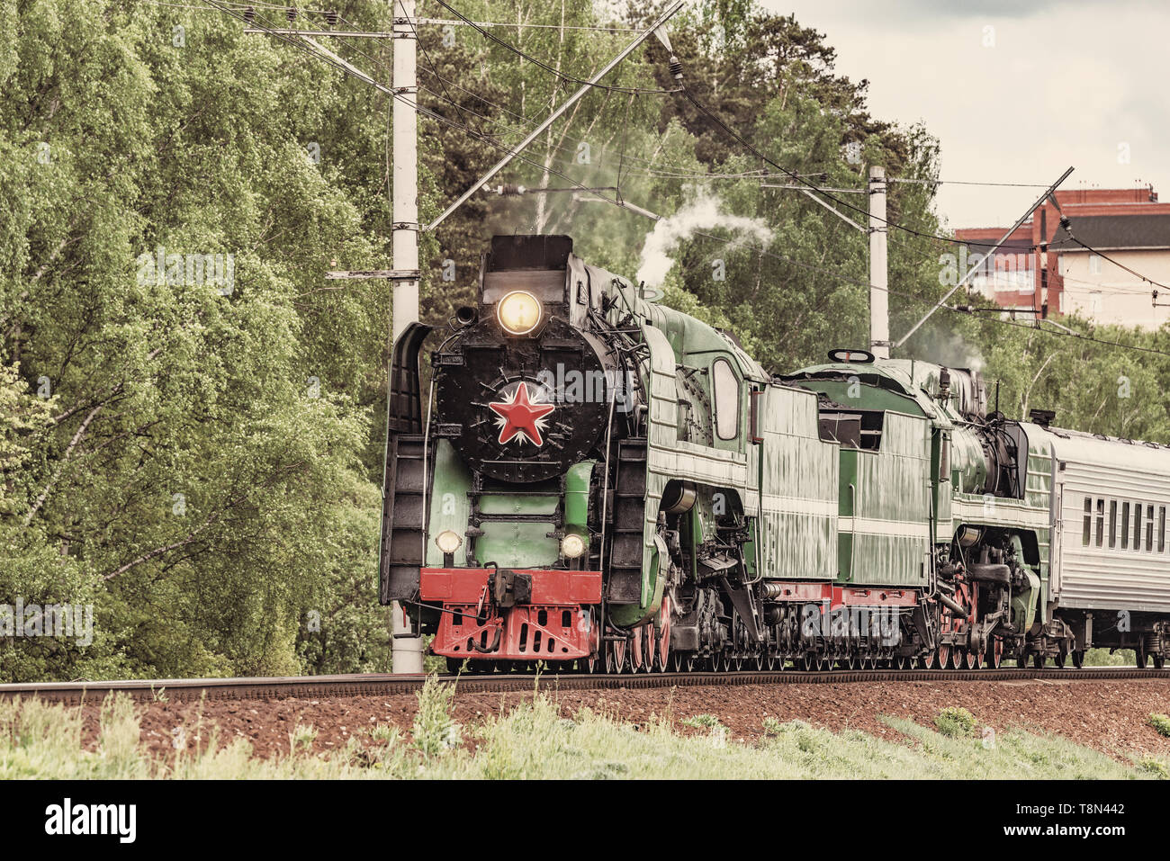 Retro steam train approaches to the station Stock Photo - Alamy