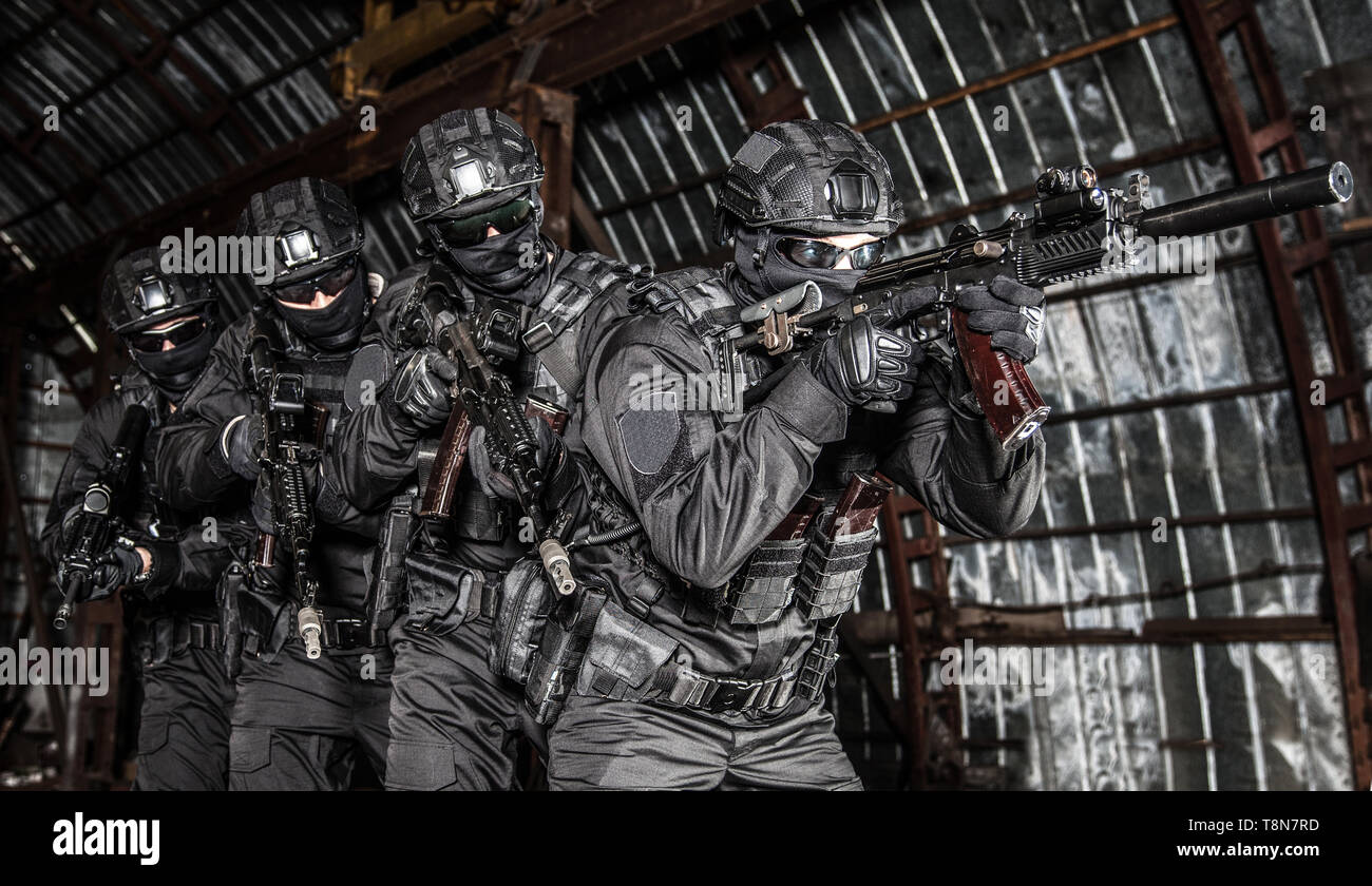 Police tactical group sneaking in industrial area Stock Photo - Alamy