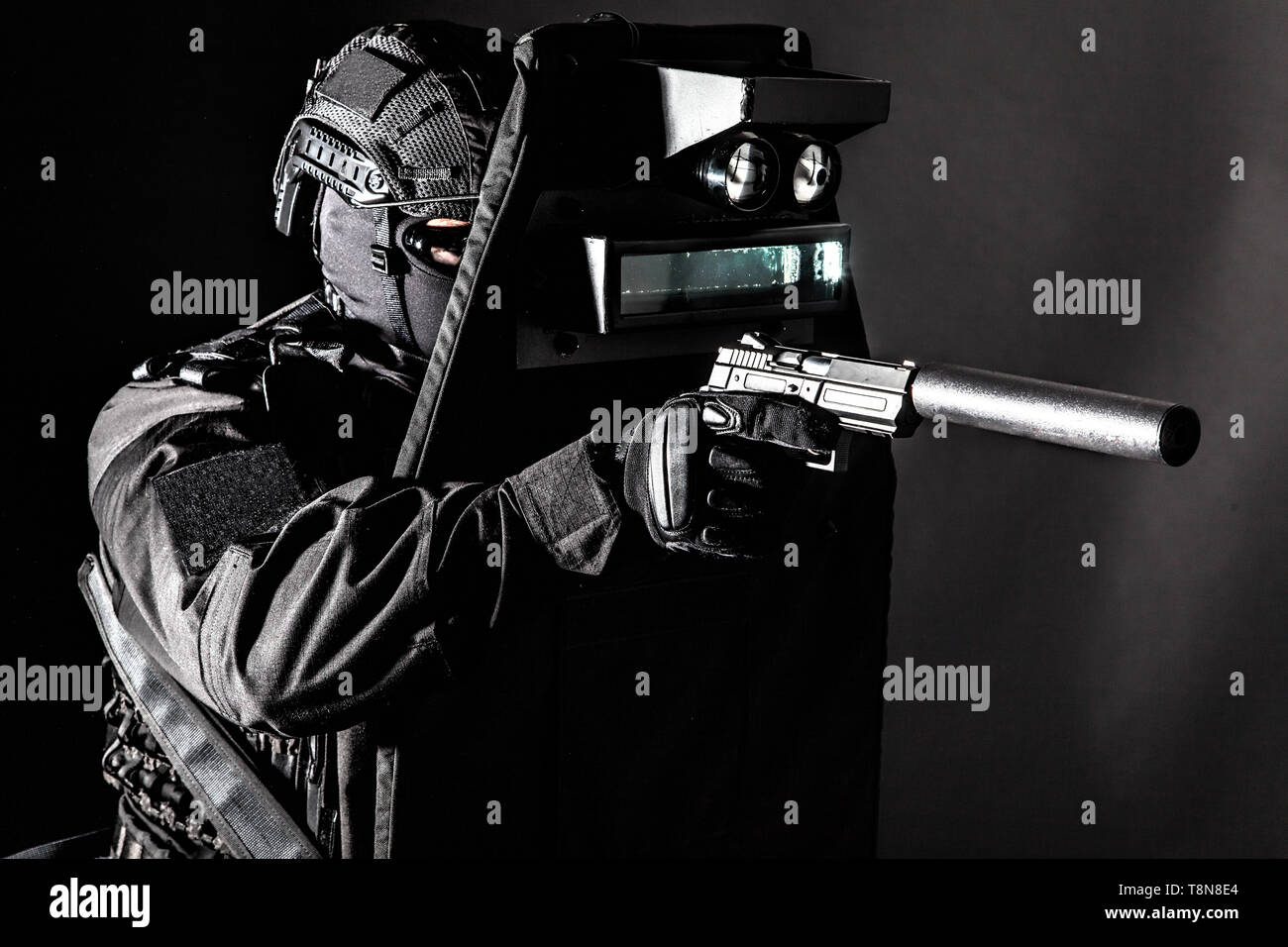 Armed SWAT fighter hiding behind ballistic shield Stock Photo - Alamy