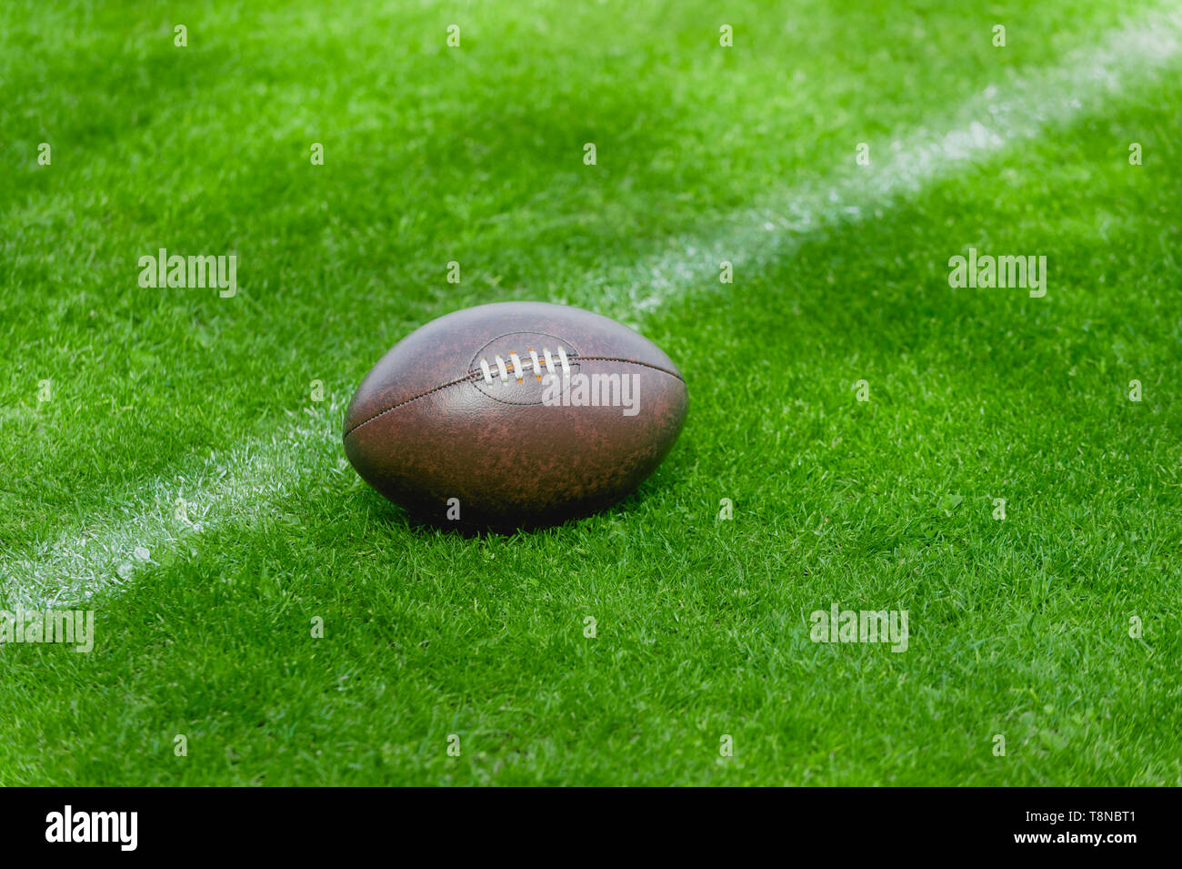 American football, rugby ball on green grass field background Stock ...