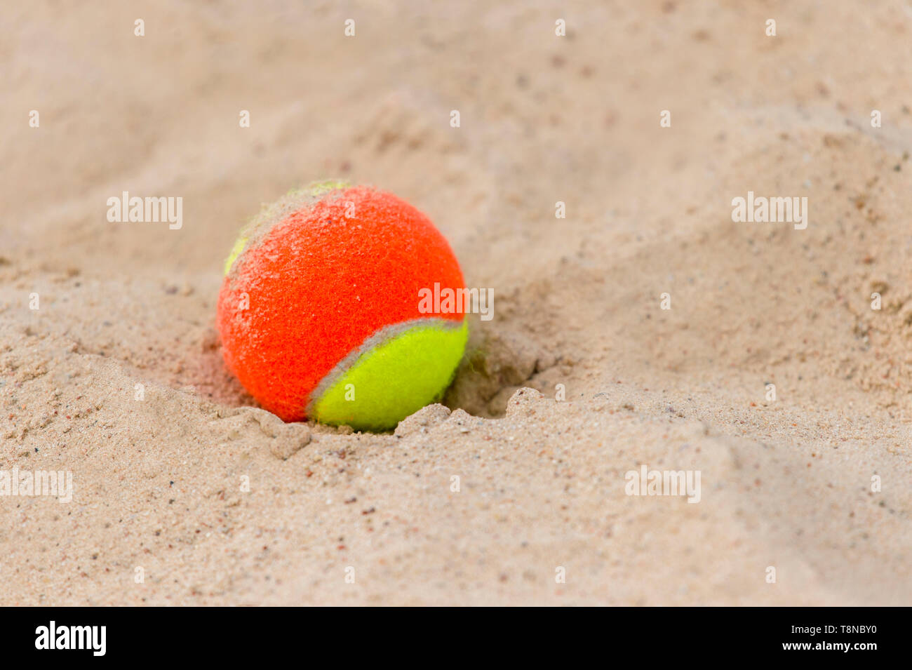 tennis ball on the sand at the beach close up Stock Photo - Alamy
