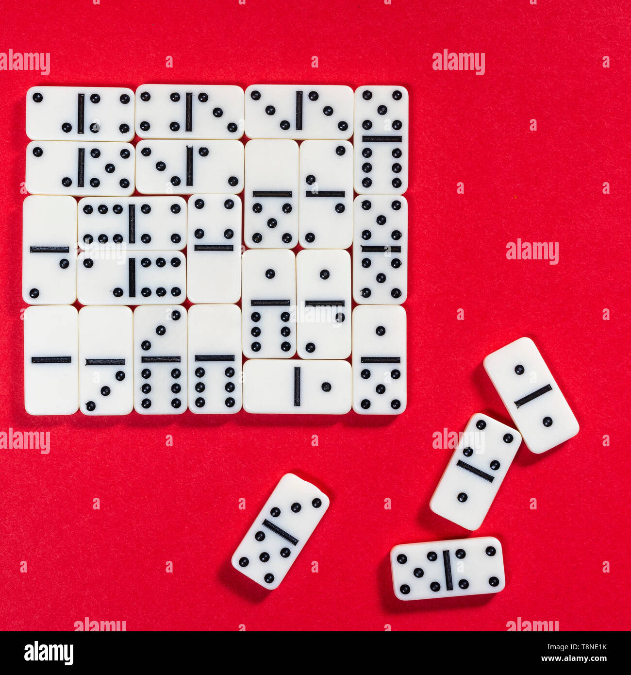 the domino game pieces on a red colored surface Stock Photo - Alamy