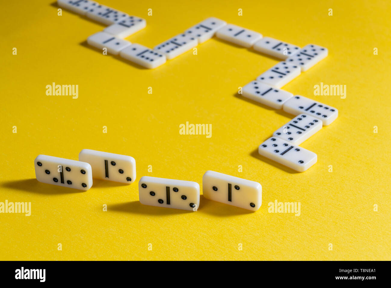 the domino game pieces on a yellow colored surface Stock Photo - Alamy