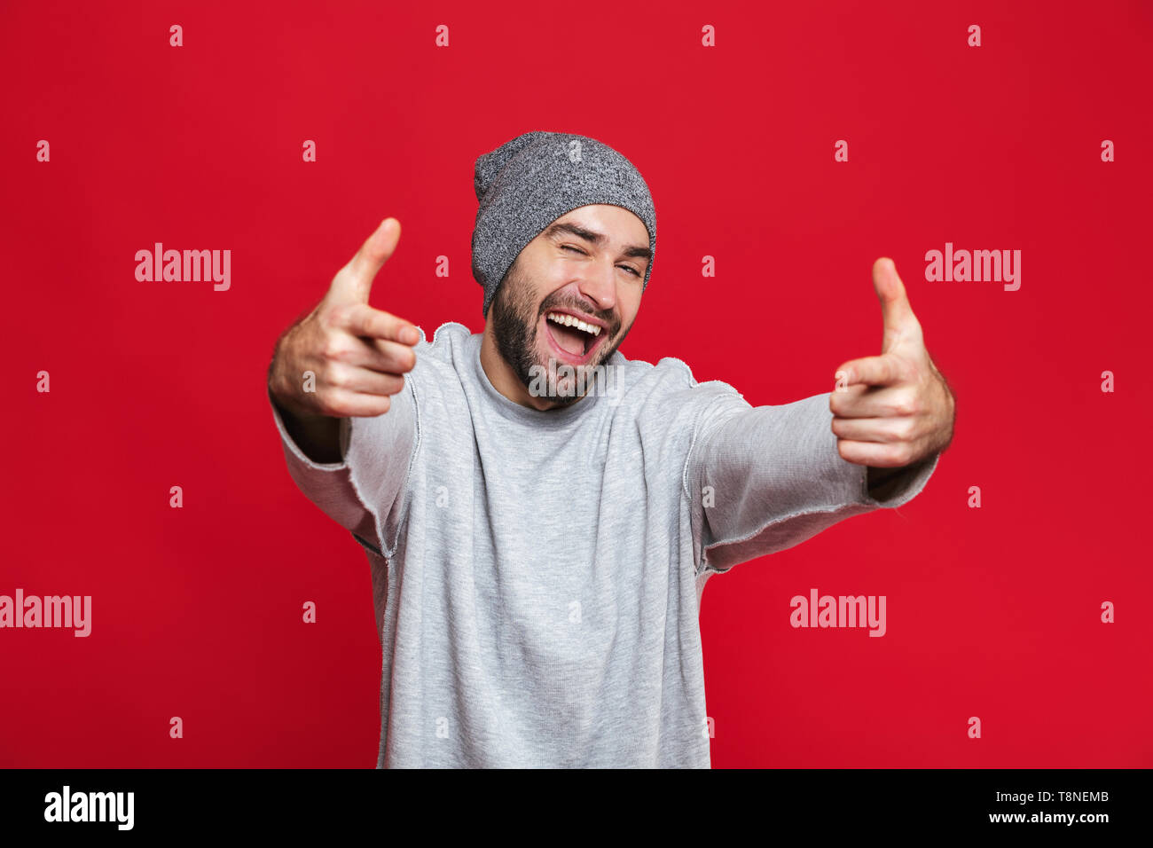 Image of smiling man 30s with beard and mustache pointing fingers at ...