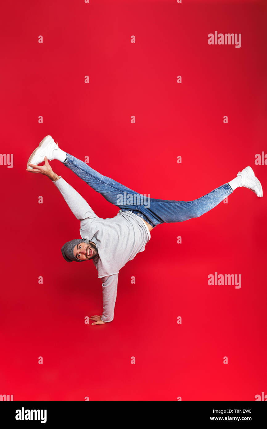 Full length image of young man 30s with beard and mustache standing ...