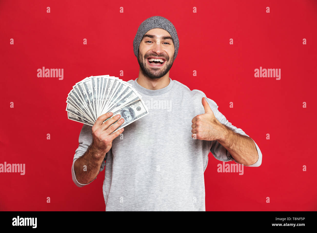 Image of european man 30s wearing hat holding money fan isolated over ...