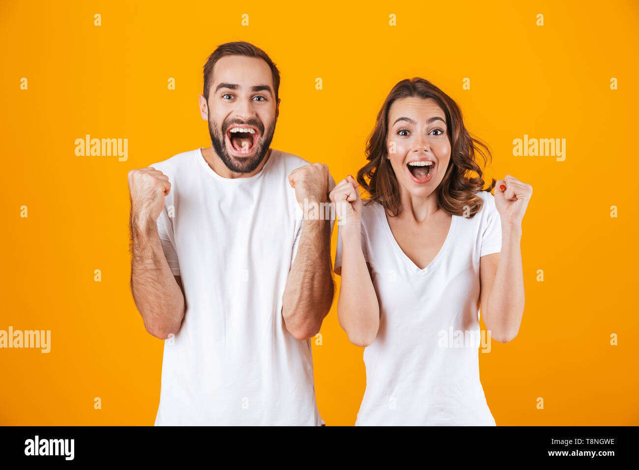 Image of ecstatic people man and woman in basic clothing laughing while ...