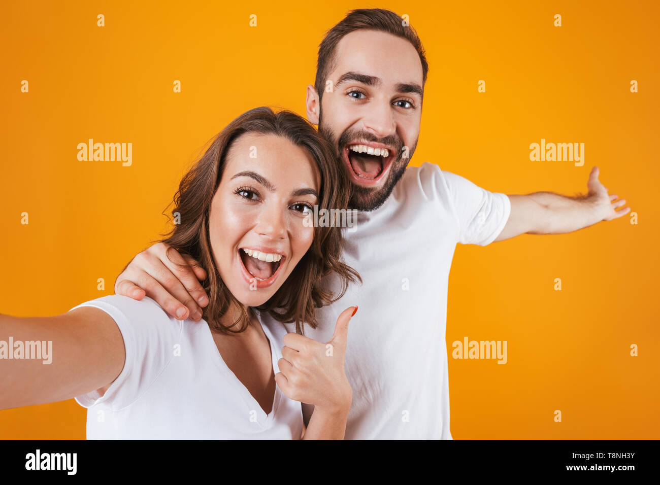 Portrait of two happy people man and woman smiling while taking selfie ...