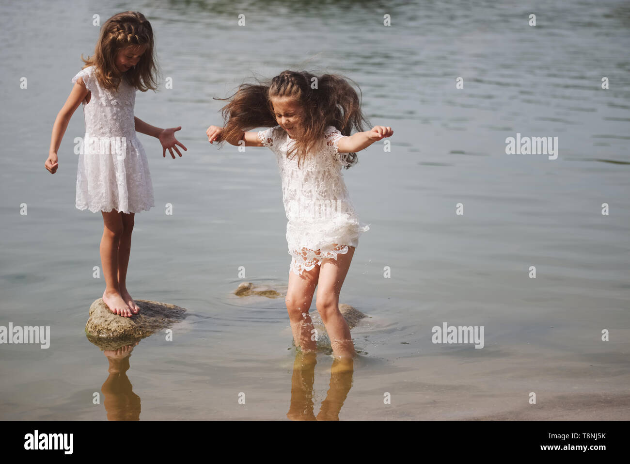 cute happy little girls in sumer lake Stock Photo - Alamy