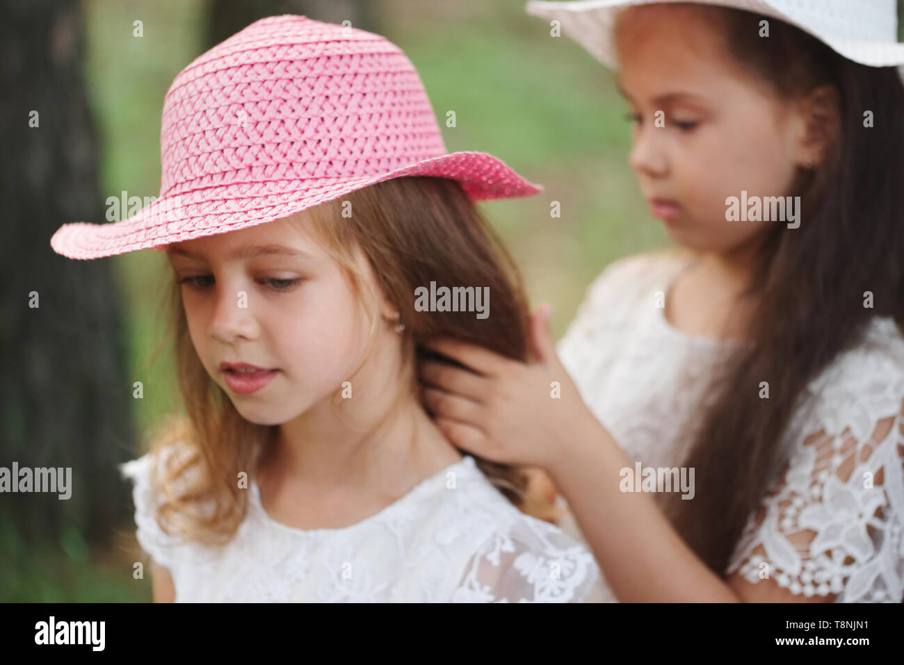 girl braids her friend's braid in park Stock Photo - Alamy