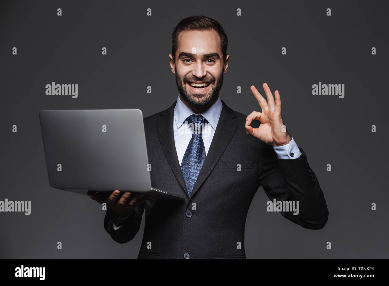 Portrait of a confident handsome businessman wearing suit isolated over ...