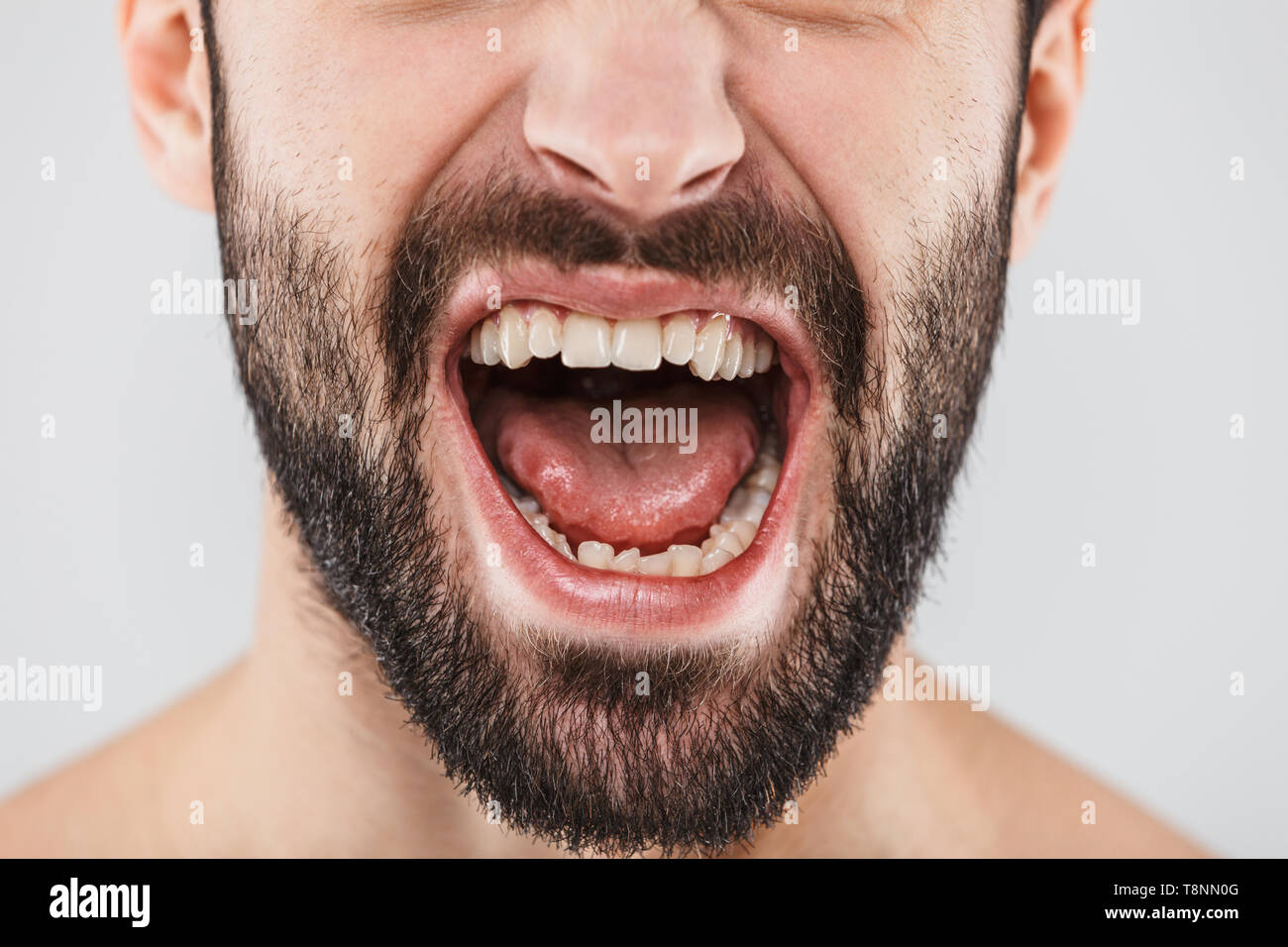 Close up half face portrait of a smiling bearded man isolated over ...