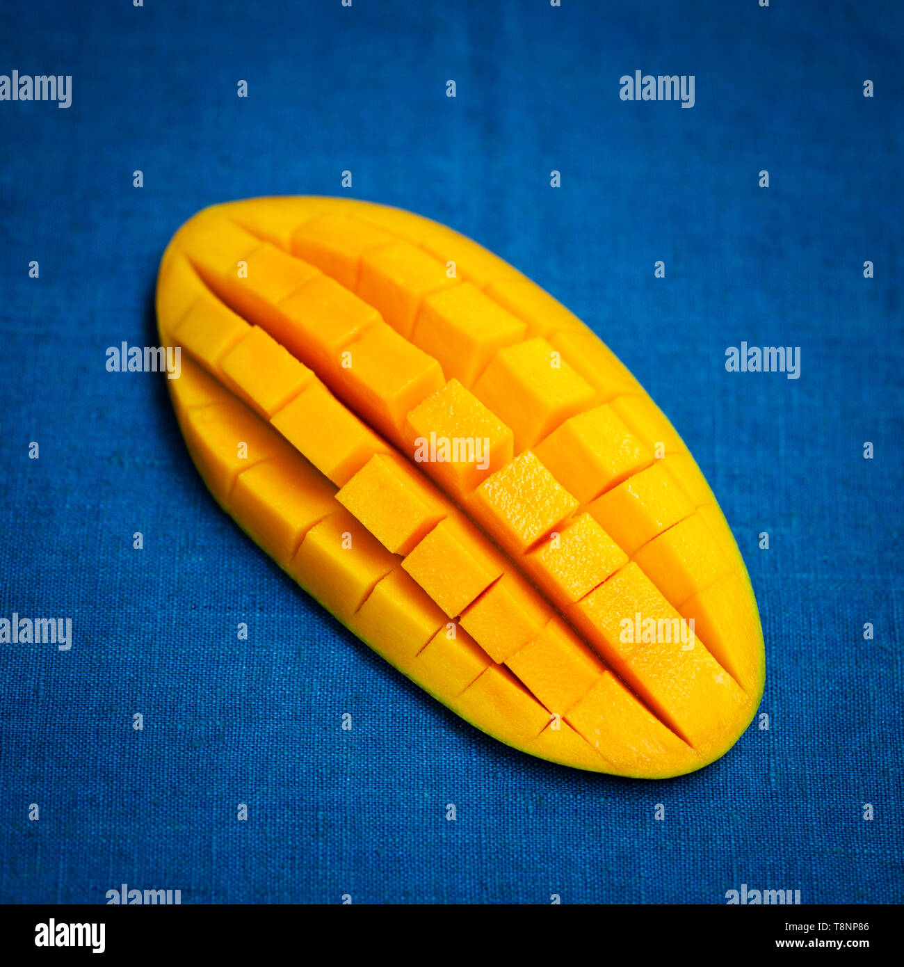Fresh mango organic product on blue textile background. Close up Stock ...