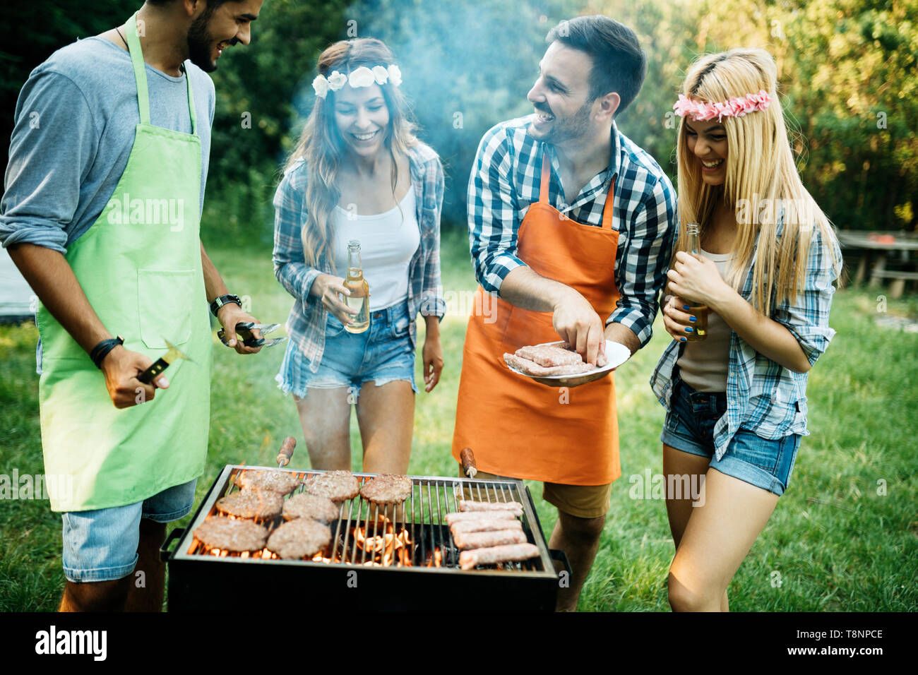 Group of friends making barbecue in the nature Stock Photo - Alamy