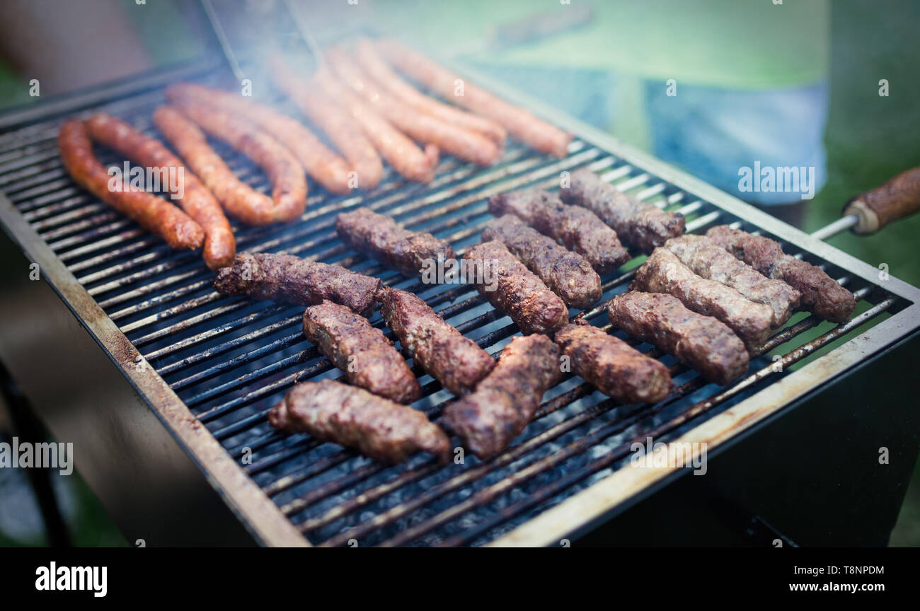 Delicious assorted grilled meat with vegetables over the coals on ...