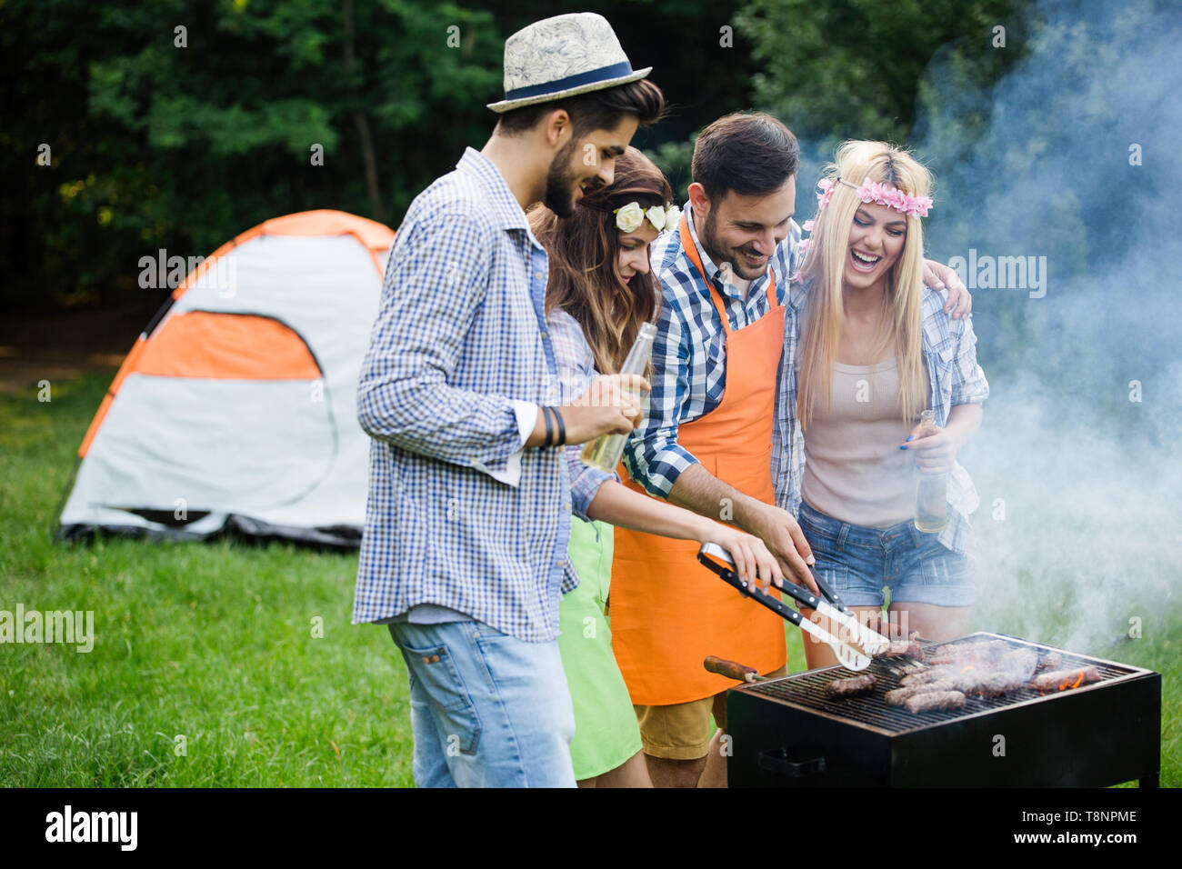 Group of friends making barbecue in the nature Stock Photo - Alamy