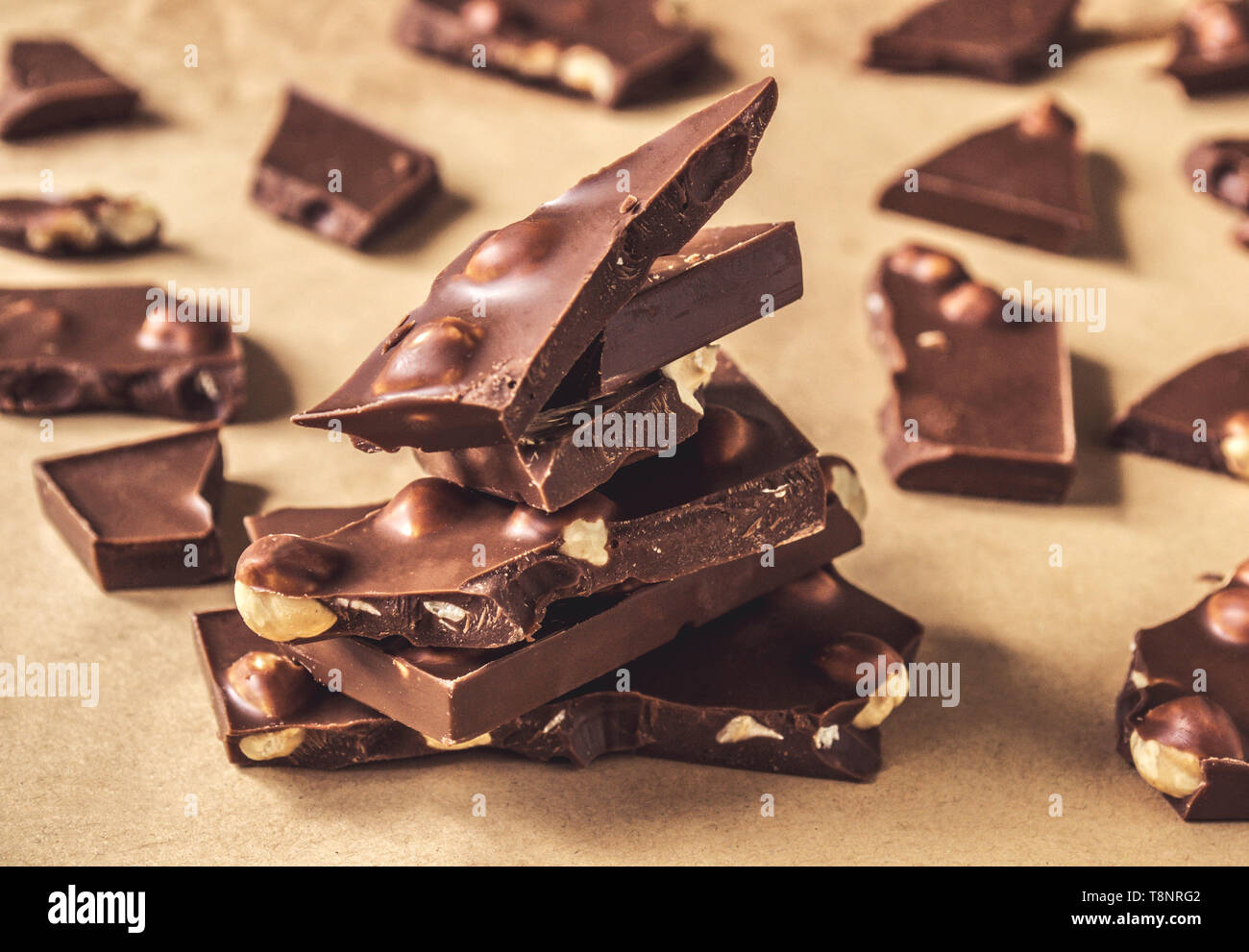 Cracked chocolate bar with hazelnuts on wrapping paper Stock Photo - Alamy