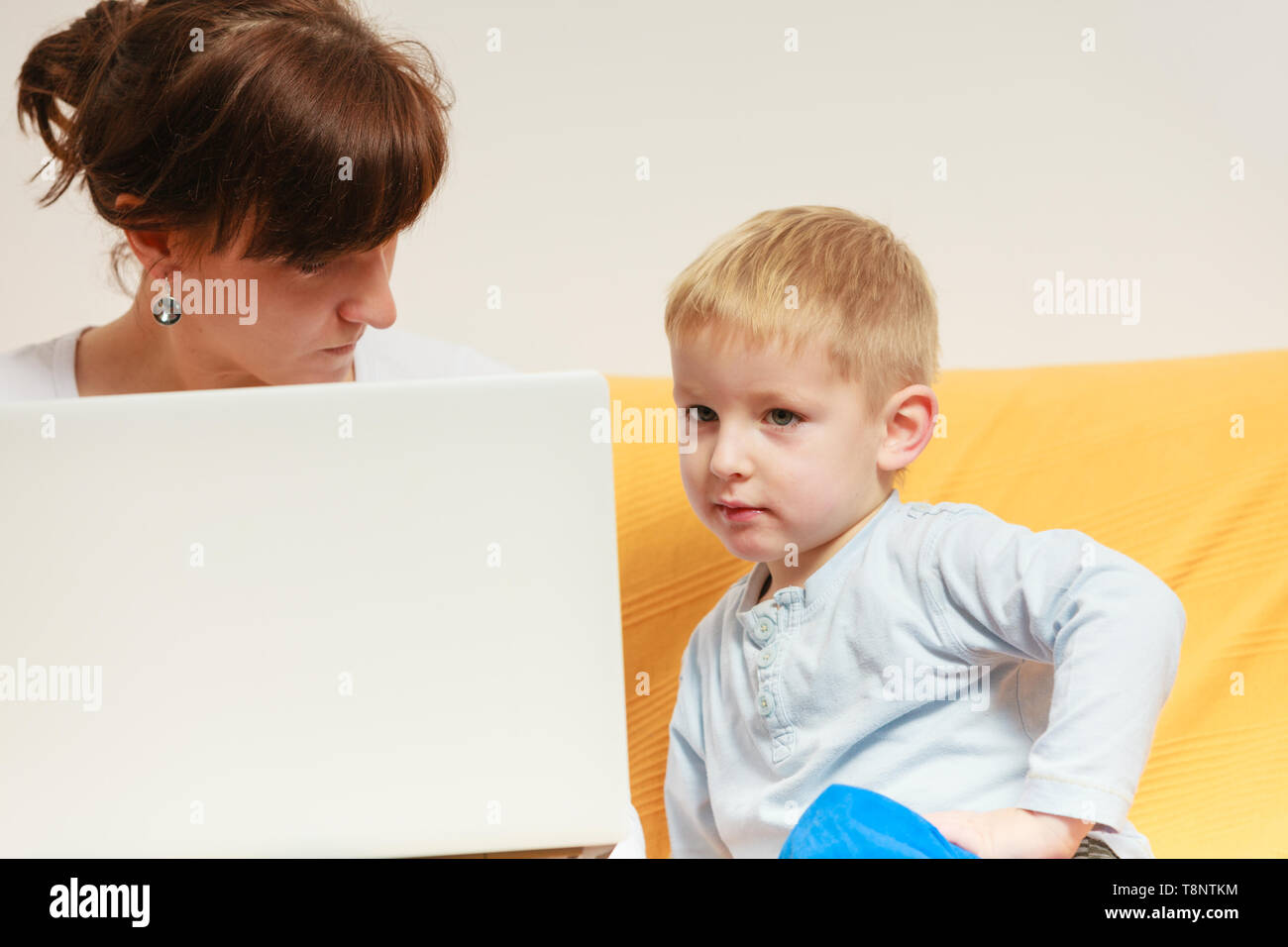 Working at home problems concept. Mother working and using laptop her ...